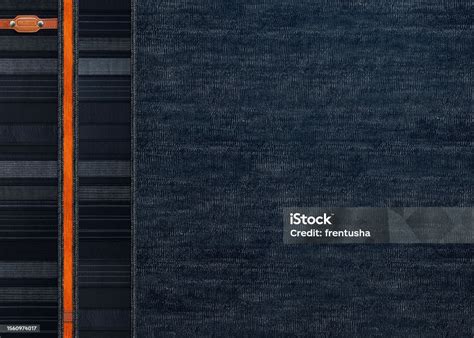줄무늬 테두리와 작은 가죽 라벨이 있는 검은색 데님 배경 짙은 회색과 오렌지 색상의 데님 청바지 패브릭 질감 텍스트 공간 복사