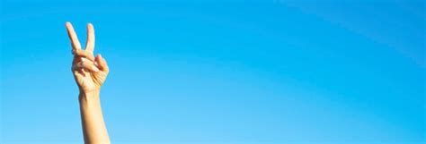 V 승리 제스처 손과 푸른 하늘 배경에 대해 손가락으로 전쟁 사랑 평화를 중지 우크라이나어 및 러시아 충돌 브레이크 아웃 평화 손 제스처 배너 헤더 복사 공간 개념