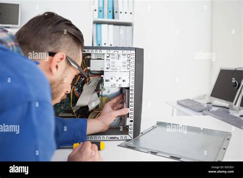 Computer Engineer Working On Broken Console With Screwdriver Stock