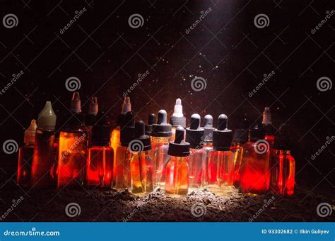 Vape Concept Smoke Clouds And Vape Liquid Bottles On Dark Background