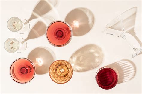 와인 칵테일 음료 밝은 베이지색 배경에 긴 태양 그림자를 위한 다양한 안경 와인 시음 또는 여름 방학의 개념 유리잔에 대한 스톡