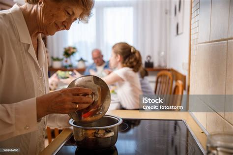 난로 꼭대기 위에 서서 웃는 노인 여성이 가족을 위해 저녁 식사를 요리합니다 실내에 대한 스톡 사진 및 기타 이미지 실내 12 13세 70 79세 Istock