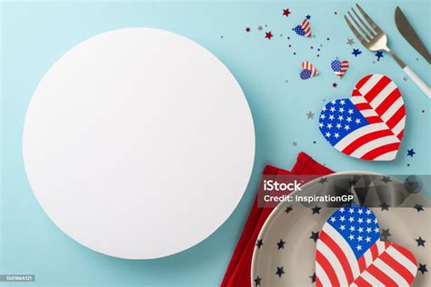 독특한 테이블 세팅으로 미국 독립 기념일을 준비하십시오 접시 식기 냅킨 미국 국기가 있는 하트 파스텔 블루 배경에 색종이 조각 텍스트 또는 광고를 위한 서클 제공 0명에