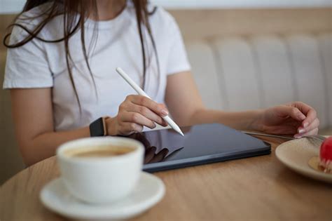 젊은 그래픽 디자이너는 스타일러스 펜으로 태블릿 컴퓨터에 그림을 그립니다 프리랜서 일러스트레이터가 스케치를 만드는 사람 카페에서