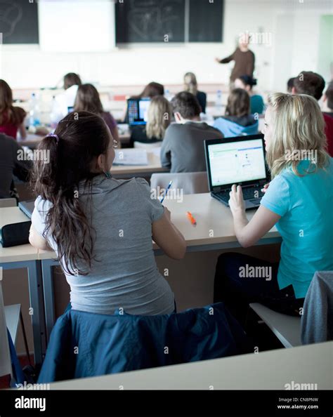 Young Pretty Female College Student Sitting In A Classroom Full Of