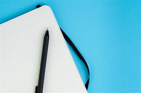 작업 프로젝트에 비즈니스 성능 회의 노트 쓰기 메시지 또는 작업 목록으로 사용 하 여 단단한 파란색 Backgrond에 펜 빈 그래프 종이 페이지 노트북 열기 개념에 대한