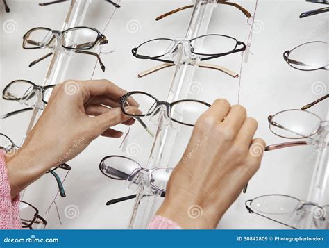 Closeup Of Hands Pulling Glasses From Display Rack Stock Image Image
