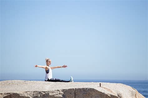 금발 여성 피트 니스 모델 명상 하 고 바다가 내려다 보이는 화강암 바위에 요가 하 고 건강한 생활방식에 대한 스톡 사진 및