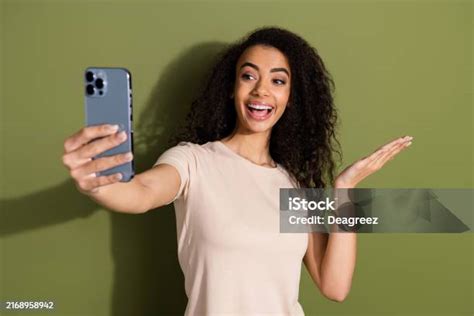 낙천적 인 소녀 옷 베이지 색 티셔츠 셀카 만들기 스마트 폰 손바닥 홀드 개체 빈 공간 카키 색 배경에 고립 된 사진 18 19세에 대한 스톡 사진 및 기타 이미지 Istock