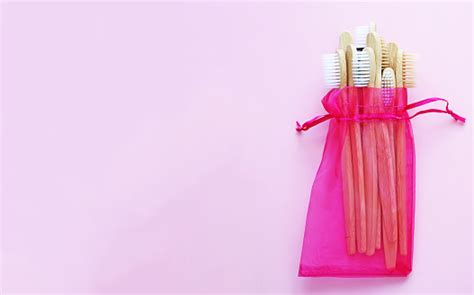 트렌디한 핑크 색으로 재사용 가능한 진홍색 파우치의 대나무 칫솔 친환경 제품 에코 제로 폐기물 및 건강 개념 플랫 레이 텍스트에