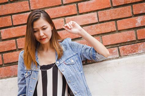 靠在旧红砖墙上的女人高清图片下载 正版图片504585703 摄图网
