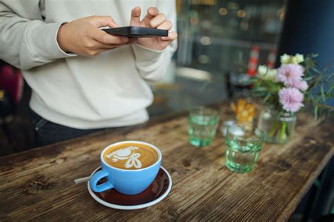 아시아 소녀는 커피 라떼에 귀여운 토끼 패턴의 사진을 찍기 위해 휴대폰을 들고 있다 Brand Name Smart Phone에 대한 스톡 사진 및 기타 이미지 Brand