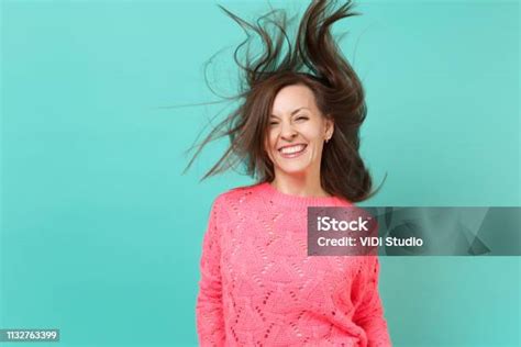 파란색 청록색 벽 배경 스튜디오 초상화에 고립 된 머리를 끼고 있는 니트 핑크 스웨터에 예쁜 젊은 여자를 웃 고 사람들은 진심으로 감정 라이프 스타일 개념입니다 복사 공간을