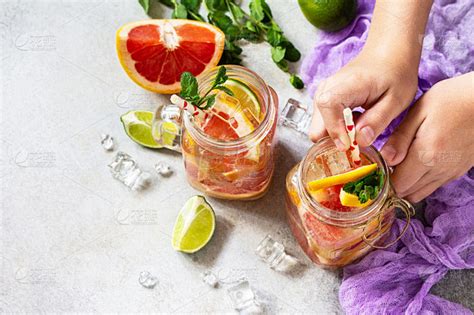 夏日清凉冰饮新鲜莫吉托鸡尾酒与葡萄柚酸橙和薄荷在一个灰色的石头背景的玻璃杯副本的空间