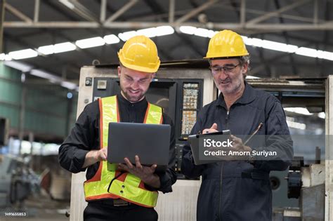 남성 엔지니어 노동자 그룹은 공장에서 노트북 컴퓨터와 토론하고 작업합니다 제조 공정 중 공장의 품질을 검사하는 남성 기술자 팀 일체감에 대한 스톡 사진 및 기타 이미지