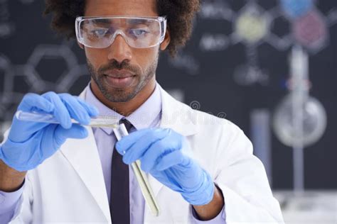 Experiments In Progress A Male Scientist Conducting An Experiment In