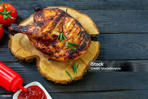 황금 갈색 크러스트와 맛있는 닭고기의 구운 부분 어두운 나무 테이블에 그릴 이나 바베큐에 요리 토마토 로즈마리 케첩 홈메이드 요리 컨셉 공간을 복사합니다 바비큐 치킨에 대한