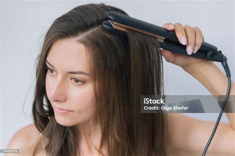 갈색 머리 여성의 클로즈업은 컬링 아이언 고프레로 머리카락의 기본 볼륨을 만듭니다 헤어 스타일리스트에 대한 스톡 사진 및 기타 이미지 헤어 스타일리스트 고데기 머리