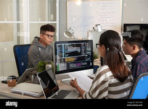 Young Woman Checking Programming Code On Computer Screen And Comparing With Code On Printed