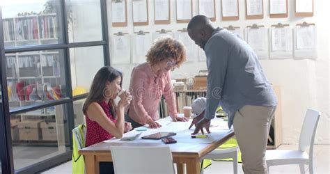Busy Diverse Architects Discussing Blueprints On Table In Office Slow Motion Stock Footage