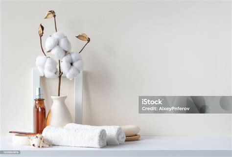 베이지 색 파스텔 톤의 욕실 인테리어 수건 비누 향수 병 헤어 브러시 하우스 플랜트가있는 욕실의 흰색 선반 텍스트 공간을 모형으로 만듭니다 최소 컴포지션 칸 가구에 대한