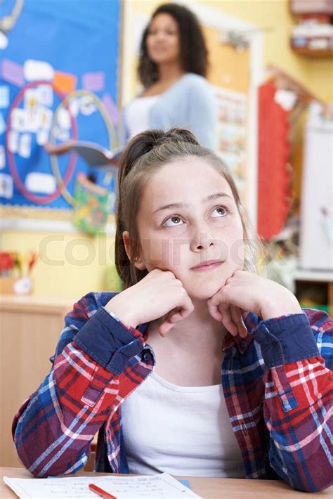 Female Elementary School Pupil Daydreaming In Class Stock Image