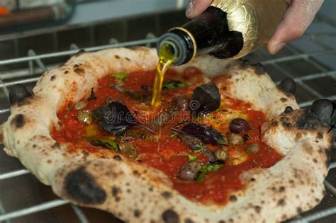 Chef Pours Olive Oil On Pizza With Slices Of Mozzarella Tomato Sauce