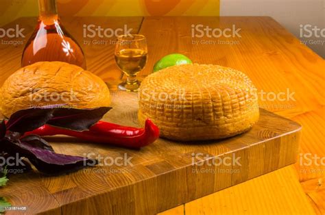 내셔널 Adyghe 치즈는 칼 바 질 파 슬 리 라임 참기름 칠리 페 퍼 마 카 다미아 너트와 나무 테이블에 디 켄 터와 함께 커팅 보드에 클로즈업 갈색에 대한 스톡 사진