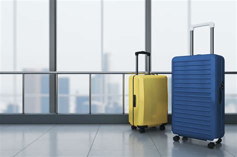 빈 공항 복도 홀에 있는 노란색과 파란색 플라스틱 여행 가방의 근접 촬영은 콘크리트 바닥과 큰 매트 창에서 도시 스카이라인을 볼 수 있습니다 3d 렌더링 3차원 형태에 대한