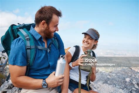 하이킹 커플 물병은 미소를 짓고 대화를 나누며 자연 속에서 야외에서 함께 행복합니다 하이킹 산맥에서 남자와 여자 휴식 휴식 유대감 사랑하고 신선한 공기로 웃어 25 29세에