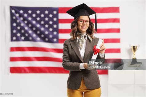 미국 국기 앞에서 졸업장을 들고 졸업 모자를 쓴 미국 여학생 25 29세에 대한 스톡 사진 및 기타 이미지 25 29세