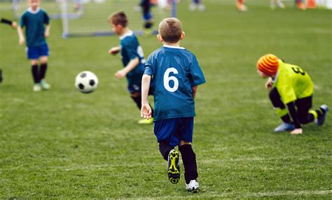 축구 게임을 하는 행복한 아이들 아이들을위한 스포츠 리그 축구 토너먼트 경기를 걷어차는 학교 소년 그룹 축구 저지 키트의 학교 소년은 잔디 밭에서 경쟁 10 11세에 대한