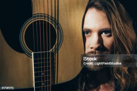 클로즈업 초상화의 잘생긴 수염 긴 머리 남자가 기타를 들고 카메라를 보고 20 29세에 대한 스톡 사진 및 기타 이미지 20 29세 검정색 배경 곡초류 Istock