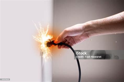 전기 플러그를 연결하는 젖은 손은 전기 충격을 일으킬 가정 화재의 원인에 대한 아이디어 전기 단락 전기 위험은 가정용품 주거 건물 전기 화재를 점화 할 수 있습니다 손에
