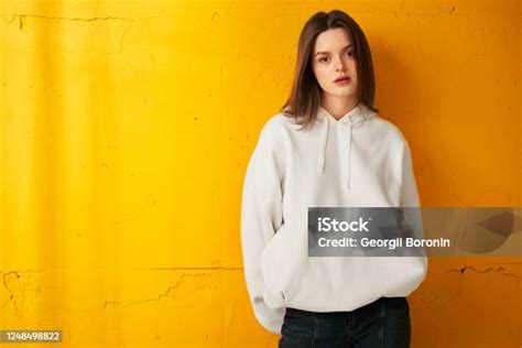 흰색 후드티를 입은 젊은 예쁜 여학생의 초상화 콘크리트 주황색 벽에 캐주얼 한 옷 후드티에 대한 스톡 사진 및 기타 이미지 후드티 운동복 여자 Istock