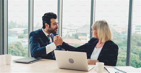 두 명의 행복한 사업가가 사무실 회의실에서 축하합니다 성공적인 사업가는 재무 데이터 보고서에 대한 대화를 나누면서 현대 직장에서 동료와 프로젝트 성공을 축하합니다 사진