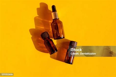 단단한 그림자가있는 밝은 모래 노란색 배경에 유리 화장품 병 뷰티 블로거 절차 살롱 개념 Minimalism 분홍색 배경에 화장품 드롭퍼 메이크업 화장품에 대한 스톡 사진