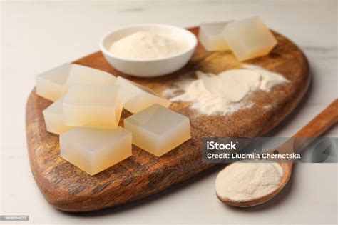 Agaragar Jelly Cubes And Powder On White Marble Table Closeup Stock