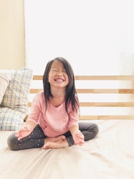 Premium Photo Cute Girl Sitting On Bed At Home