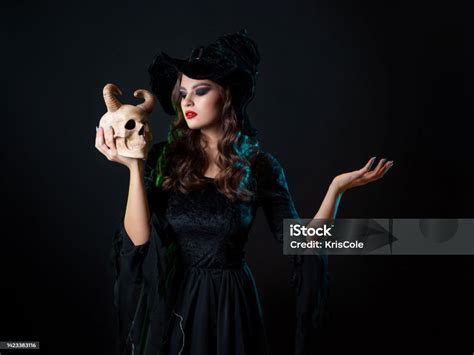 원물 모자를 쓴 젊은 아름다운 마녀가 악마의 두개골을 손에 들고 있습니다 두개골에 대한 스톡 사진 및 기타 이미지 두개골 마녀 10월 Istock
