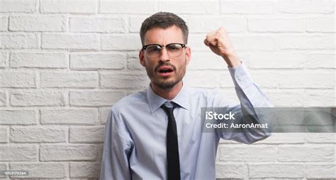 흰색 벽돌 위에 서 있는 젊은 성인 비즈니스 남자 화가 좌절 분노 미친 제기 손으로 소리와 분노 개념 소리 벽 감정에 대한 스톡