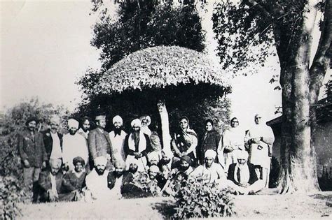 An Old Black And White Photo Of People Standing In Front Of A Tree With