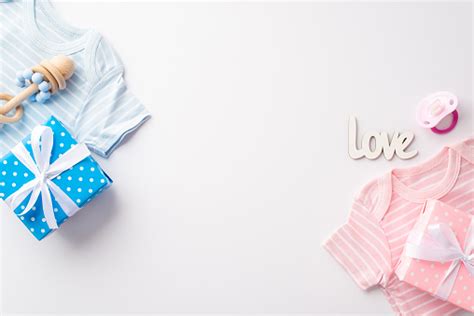 성별은 파티 개념을 공개합니다 분홍색과 파란색 유아 옷 셔츠 선물 상자 젖꼭지 나무 딸랑이와 비문 복사 공간이 있는 격리된 흰색 배경에 대한 사랑의 상위 뷰 사진 배경