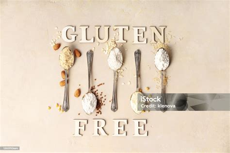 다양한 글루텐 프리 밀가루 아몬드 가루 오트밀 가루 메밀가루 쌀가루 옥수수 가루 및 나무 편지 평평한 평지 상단 보기로 만든 글루텐 프리 레터링의 금속 숟가락 개념에 대한