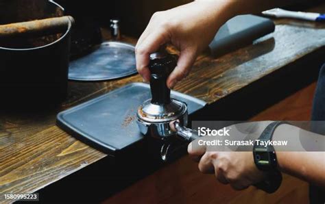 갓 볶은 스페셜티 커피를 전문 기계에 갈아주는 바리스타 커피 탬퍼와 포터필터로 맛있는 신선한 커피를 만드는 커피 추출 과정