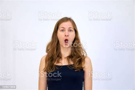 여자는 잠시 생각하고 놀랍게도 보인다 아름다운 백인 여성이 느슨한 머리를 가진 파란색 스웨터에 흰색 배경에 서있다 여자는 감정을 보여줍니다 귀여운에 대한 스톡 사진 및 기타