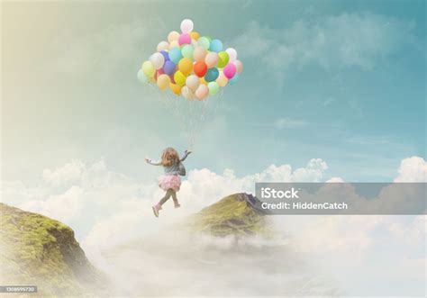 화려한 풍선을 들고 있는 어린 소녀가 한 산 꼭대기에서 다른 산 꼭대기로 뛰어들어 있습니다 성공성취 개념 복사 공간이 있는 판타지 배경 아이에 대한 스톡 사진 및 기타