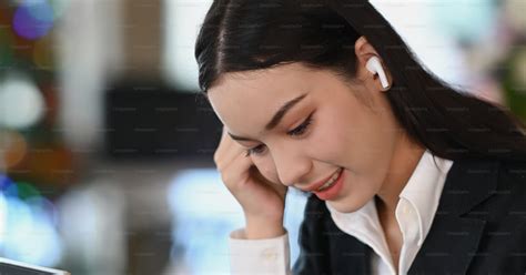 이어폰을 끼고 직장에서 컴퓨터 이야기를 하는 젊은 사업가의 초상화 사진 Unsplash의 앉아 이미지