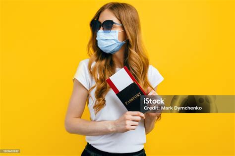 여권과 티켓을 가지고 얼굴에 의료 용 보호 마스크를 쓴 소녀 승객이 해외로 나갑니다 여행 검역 및 코로나바이러스의 개념