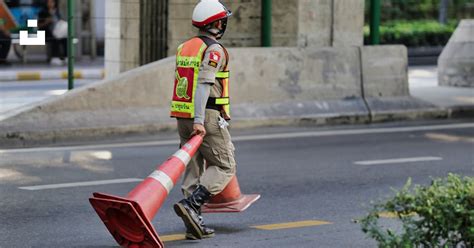 도로를 따라 주차 콘을 당기는 남자 사진 Unsplash의 무료 의복 이미지